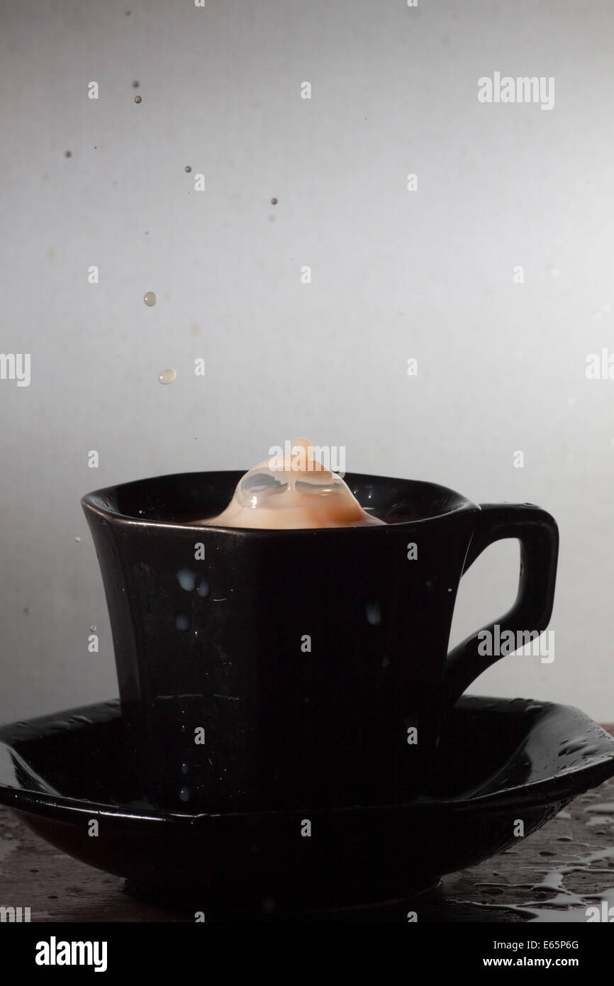 Tea being dropped in to a cup to make a splash Stock Photo - Alamy