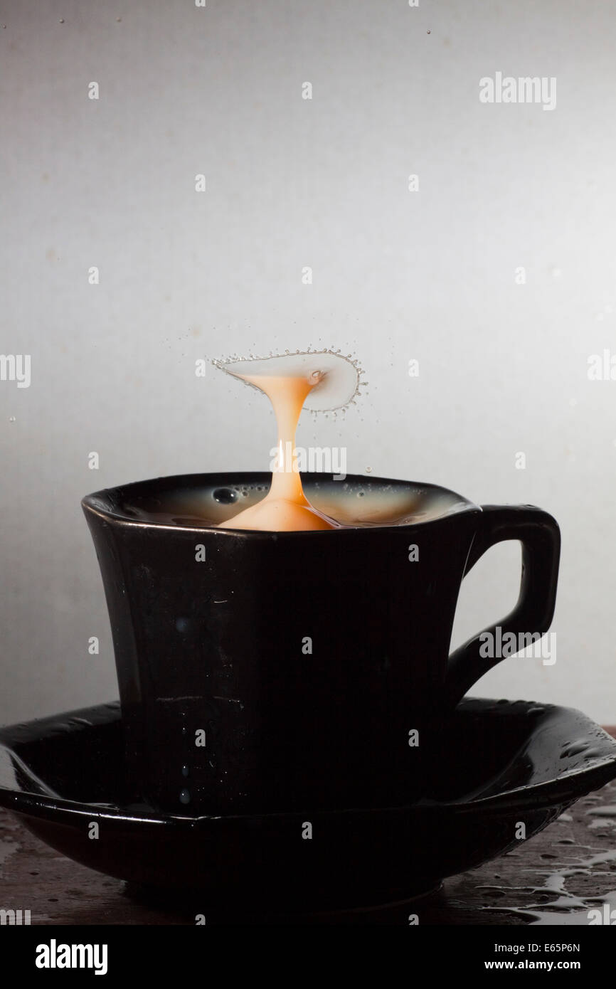 Tea being dropped in to a cup to make a splash Stock Photo - Alamy