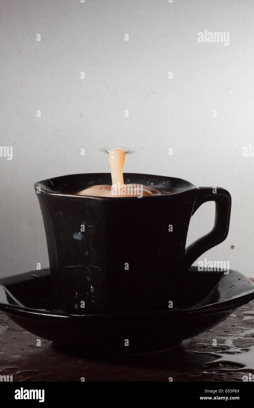 Tea being dropped in to a cup to make a splash Stock Photo - Alamy