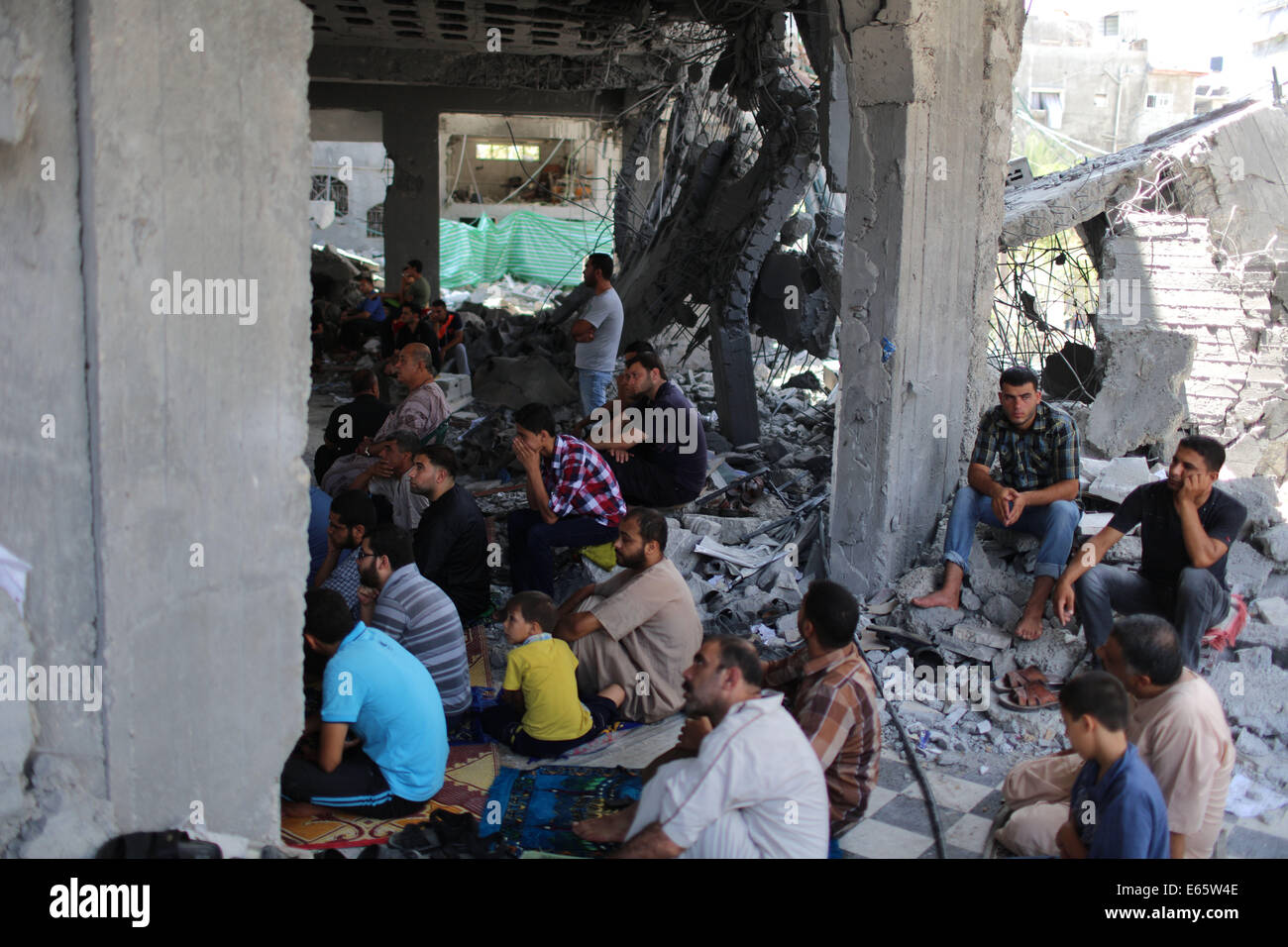 Gaza. 15th Aug, 2014. Palestinian men pray on the rubble during Friday ...