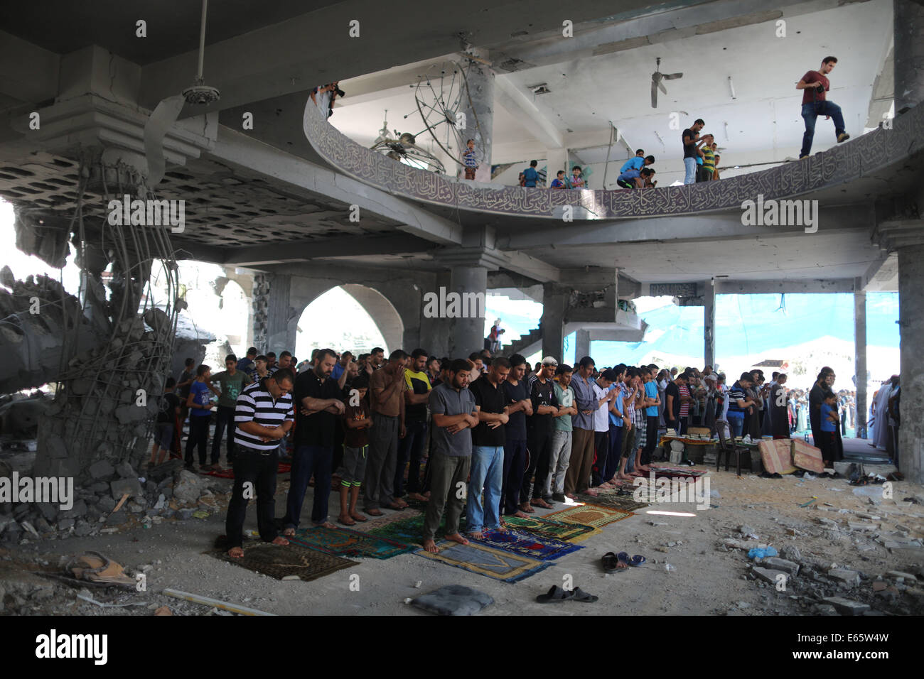 Gaza. 15th Aug, 2014. Palestinian men pray on the rubble during Friday ...