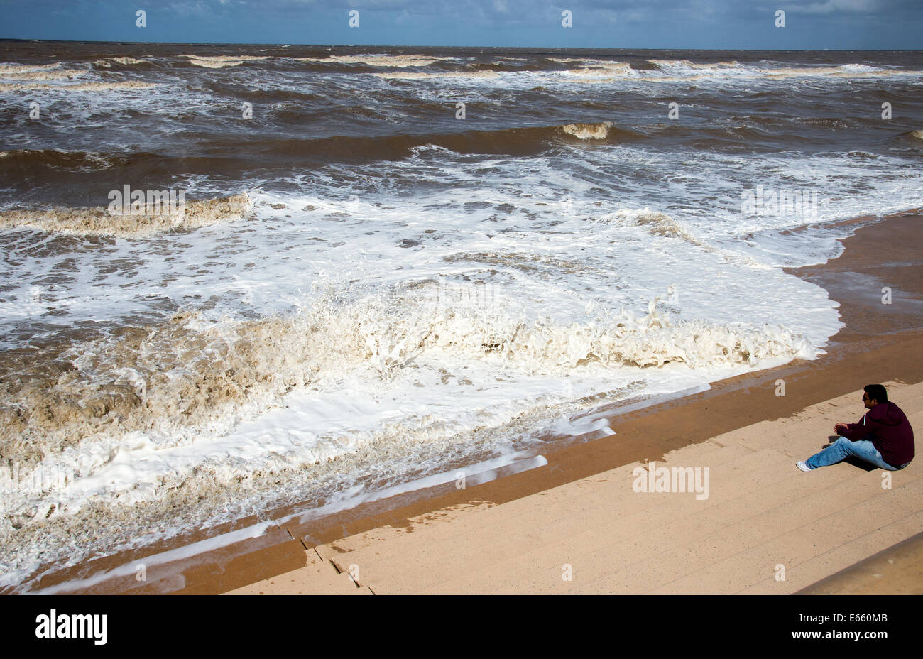 Man watches a heavy sea pounding the Blackpool Lancashire UK shoreline ...
