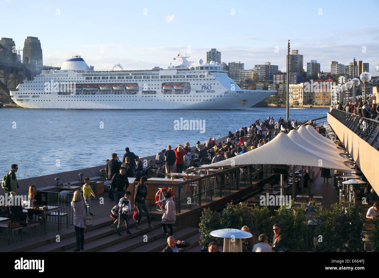 cruise liner ship passes sydney opera house and crowded opera bar ...