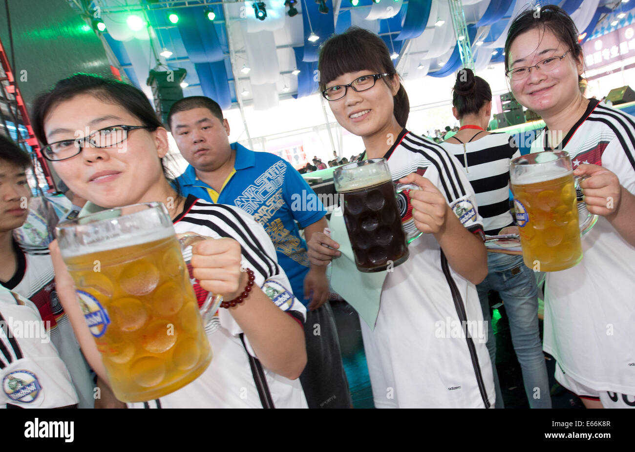 Qingdao, China. 16th Aug, 2014. Waiters carry mugs of beer during 24th ...