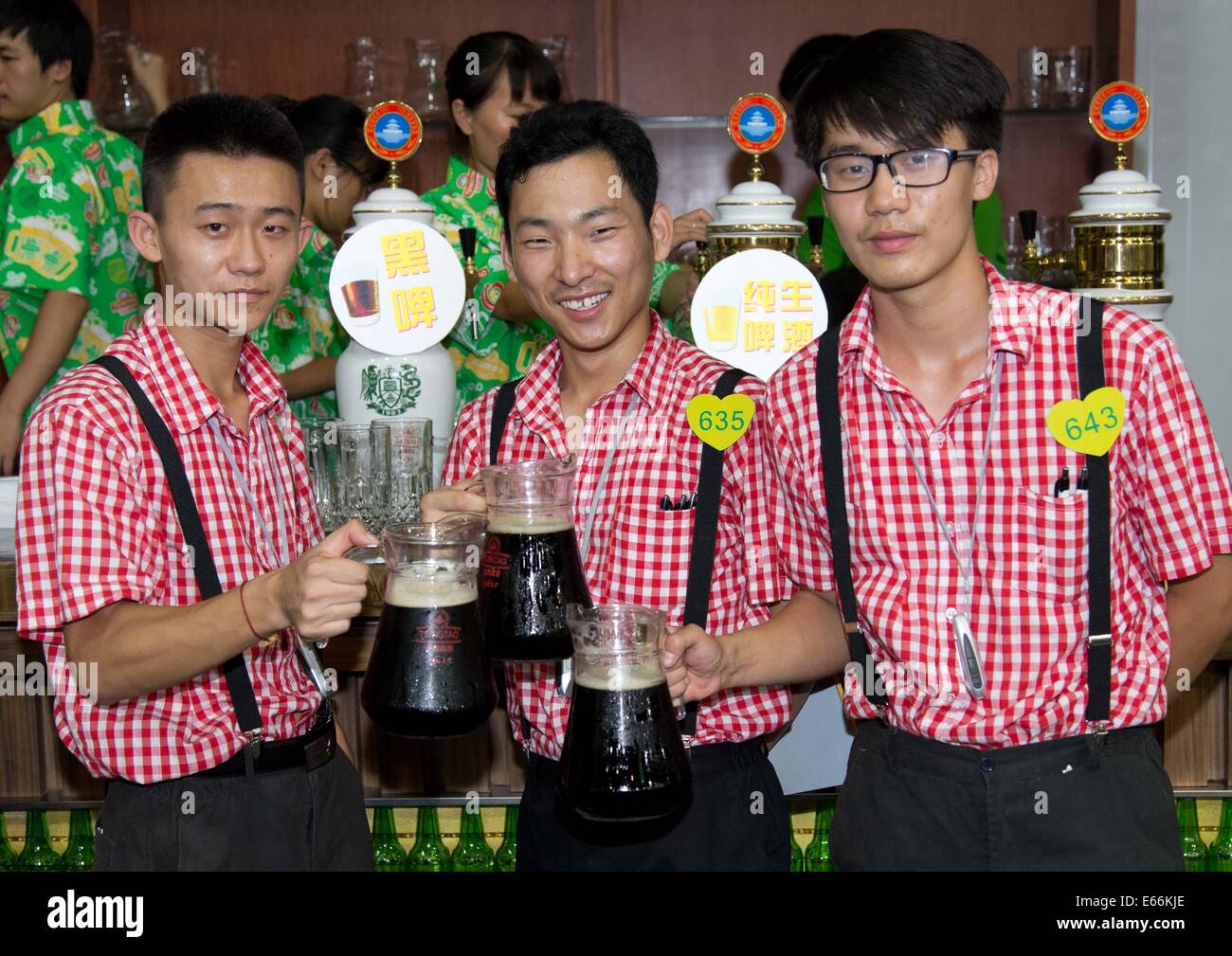 Qingdao, China. 16th Aug, 2014. Waiters carry mugs of beer during 24th ...