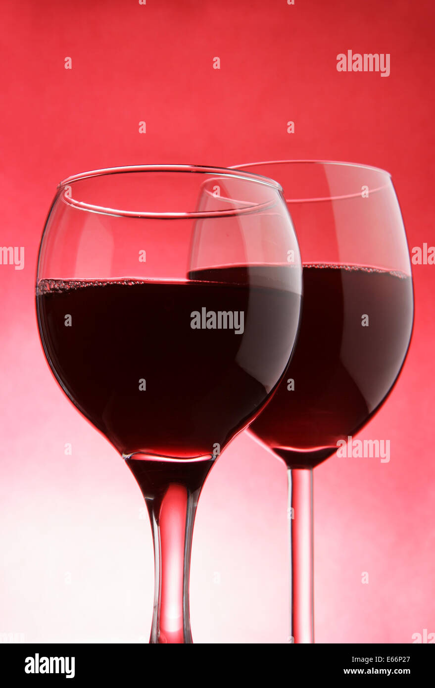 Two glasses of red wine close-up over red background Stock Photo - Alamy