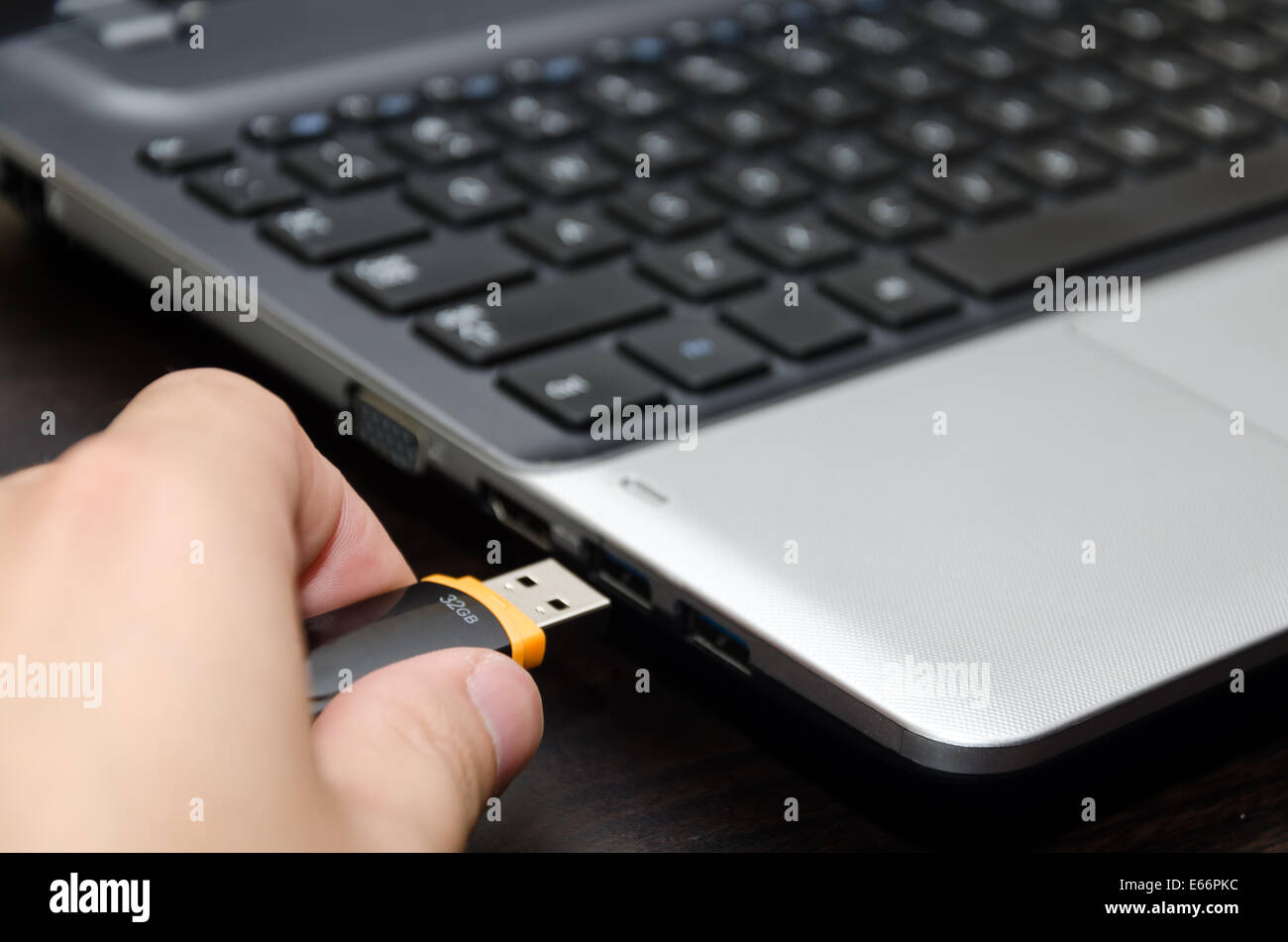 Hand with usb flash drive ans laptop Stock Photo - Alamy