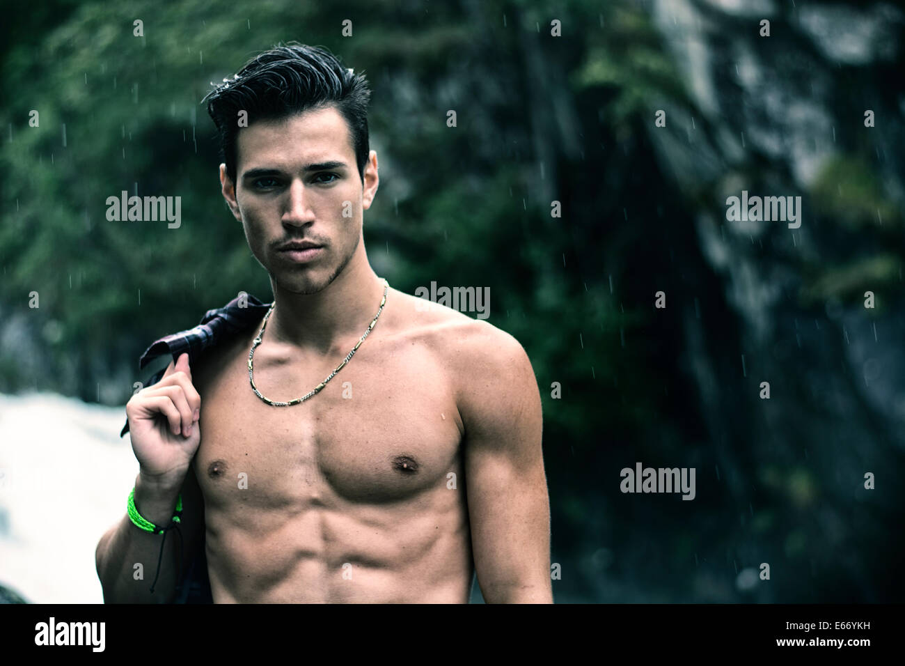 Handsome young man near mountain waterfall shirtless, under rain Stock ...