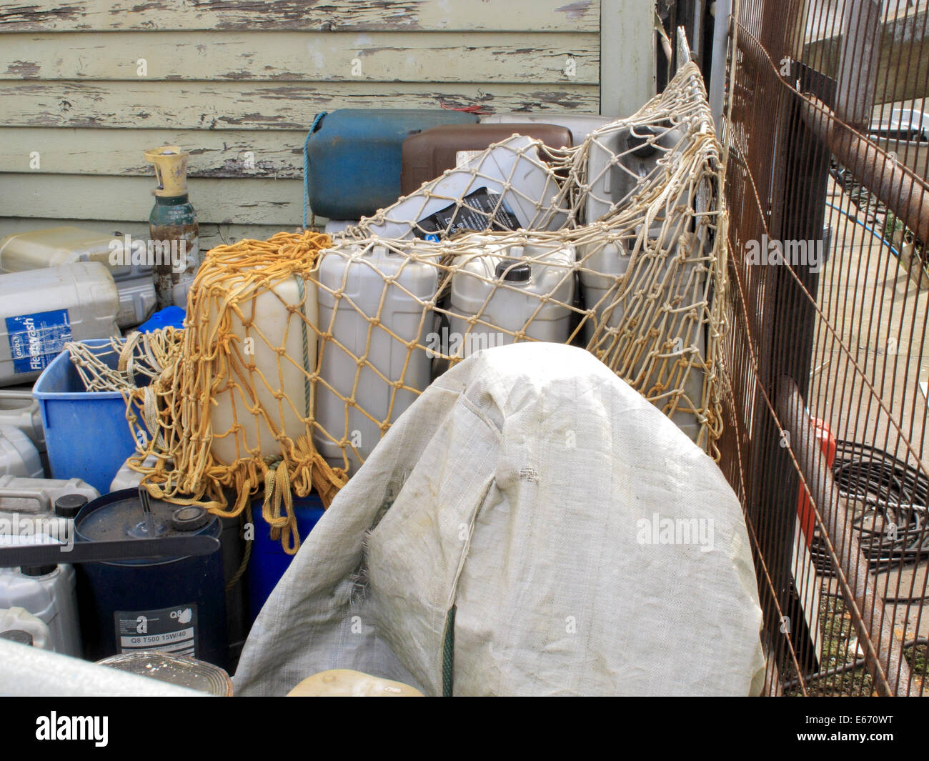 A store of old plastic containers covered by netting Stock Photo - Alamy