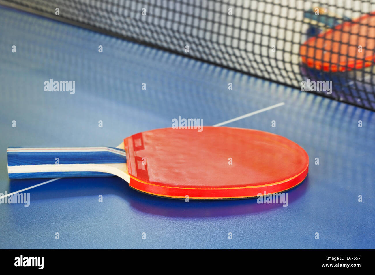 two red tennis racket on ping pong table close up Stock Photo - Alamy