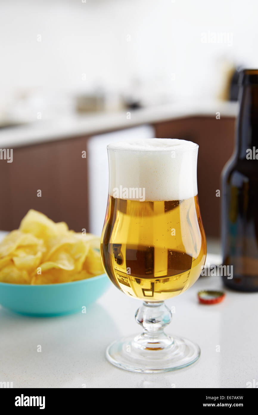 Beer glass with chips on kitchen counter Stock Photo - Alamy