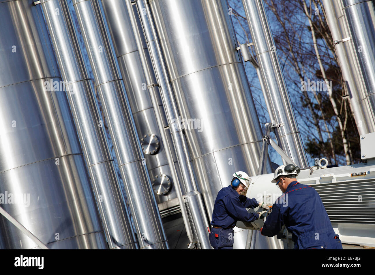 gas workers with large pipelines in background Stock Photo - Alamy