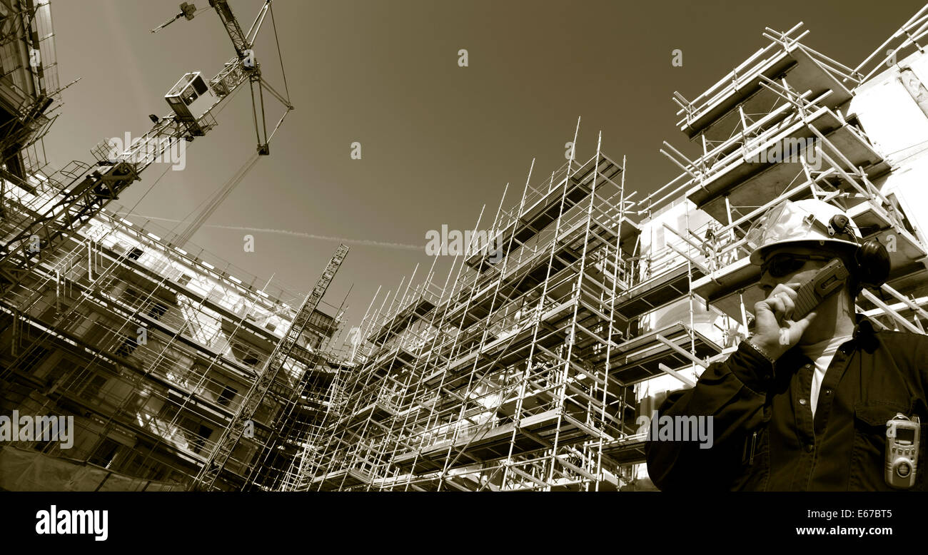 building worker inside construction site, cranes and scaffolding Stock ...