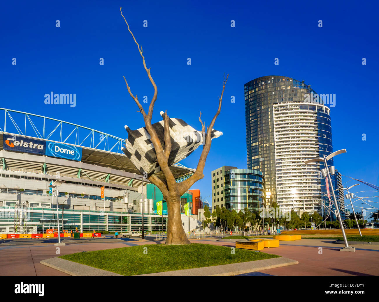Cow up a tree upside down black & white cow sculpture against deep blue ...