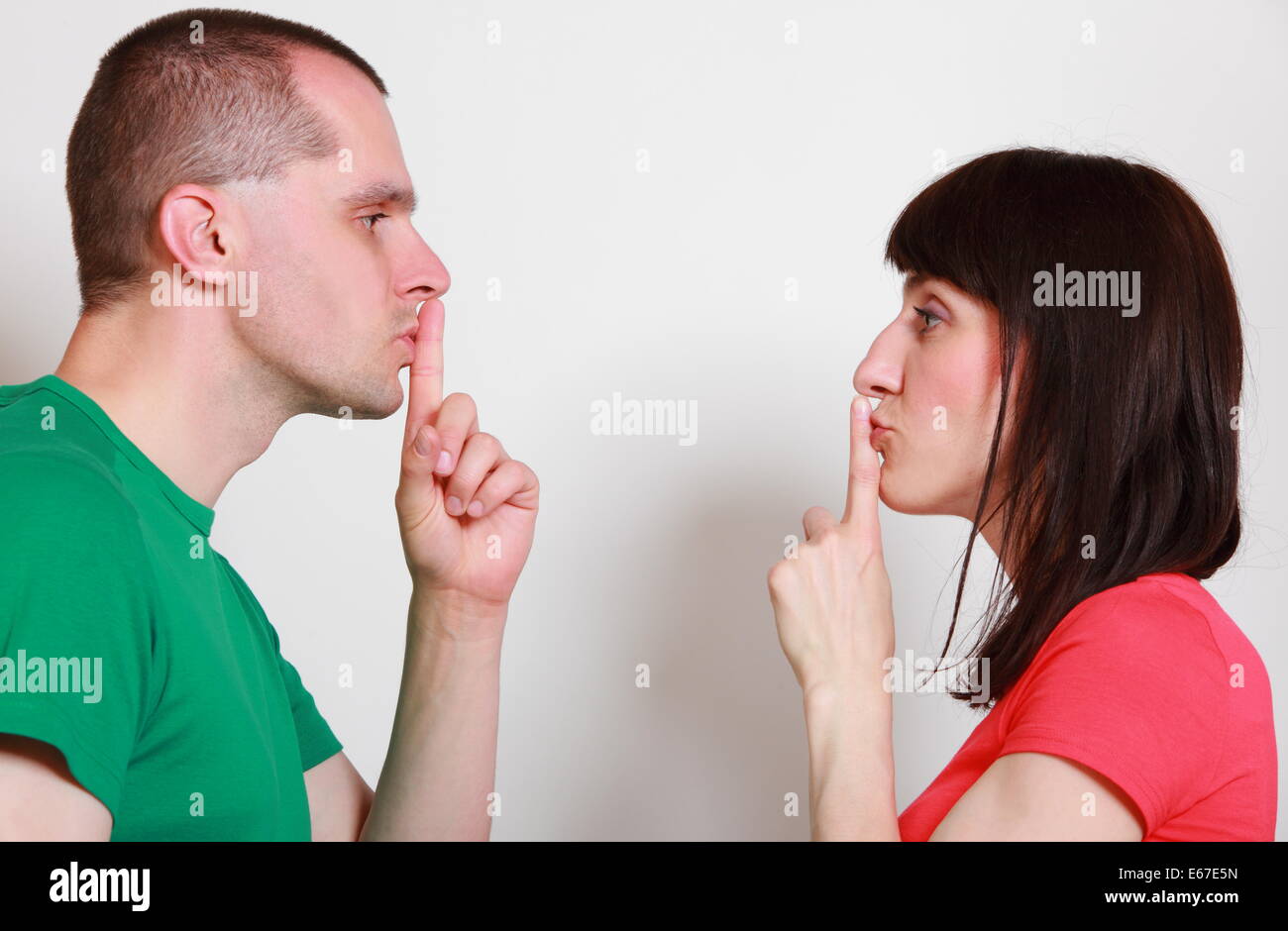 Woman and man showing hand silence sign, couple showing silence sign ...