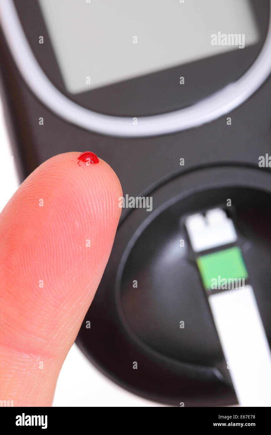 Closeup of finger with blood and glucose meter, taking blood sample ...