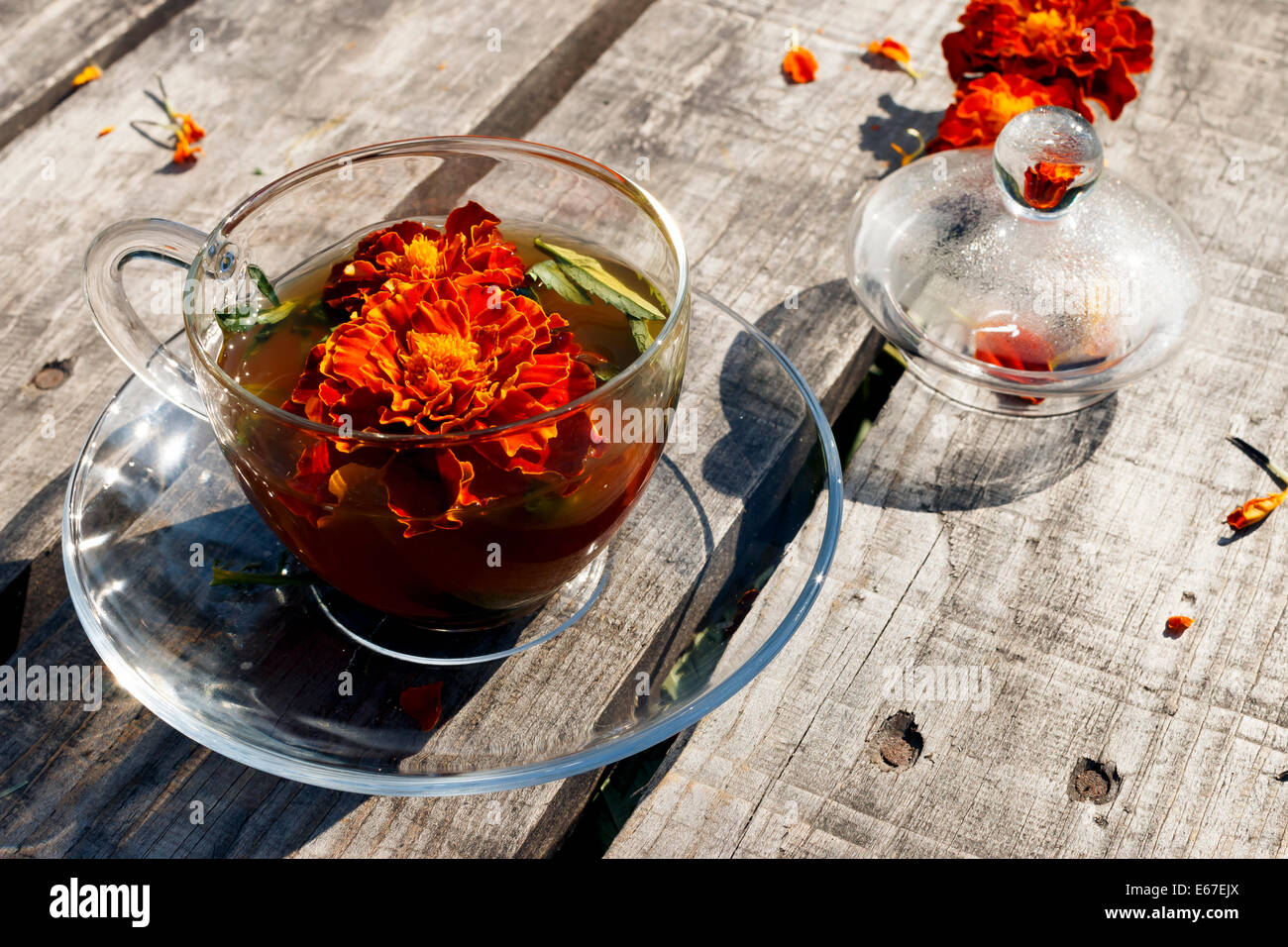 marigold tea in transparent cup and cap teapot on wooden desks Stock ...