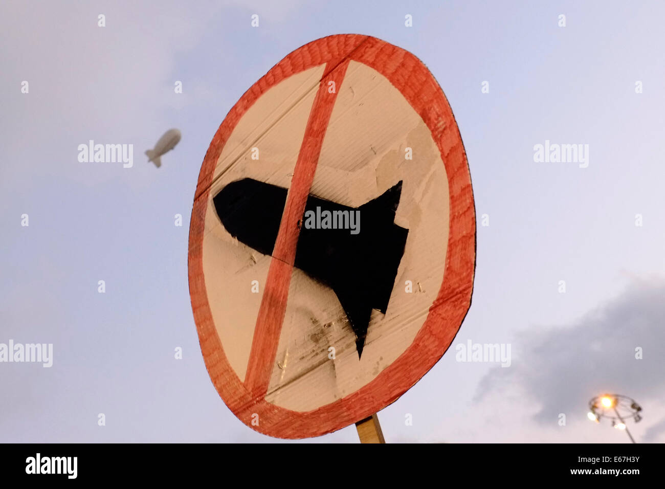 A police surveillance balloon hovering over a placard depicting "No ...
