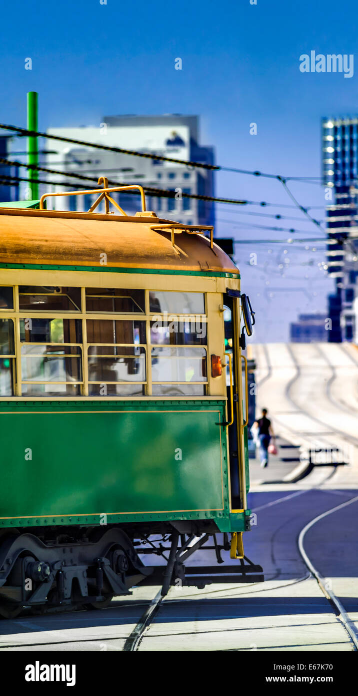 Classic green heritage iconic Melbourne tram approaching wavy tramlines ...