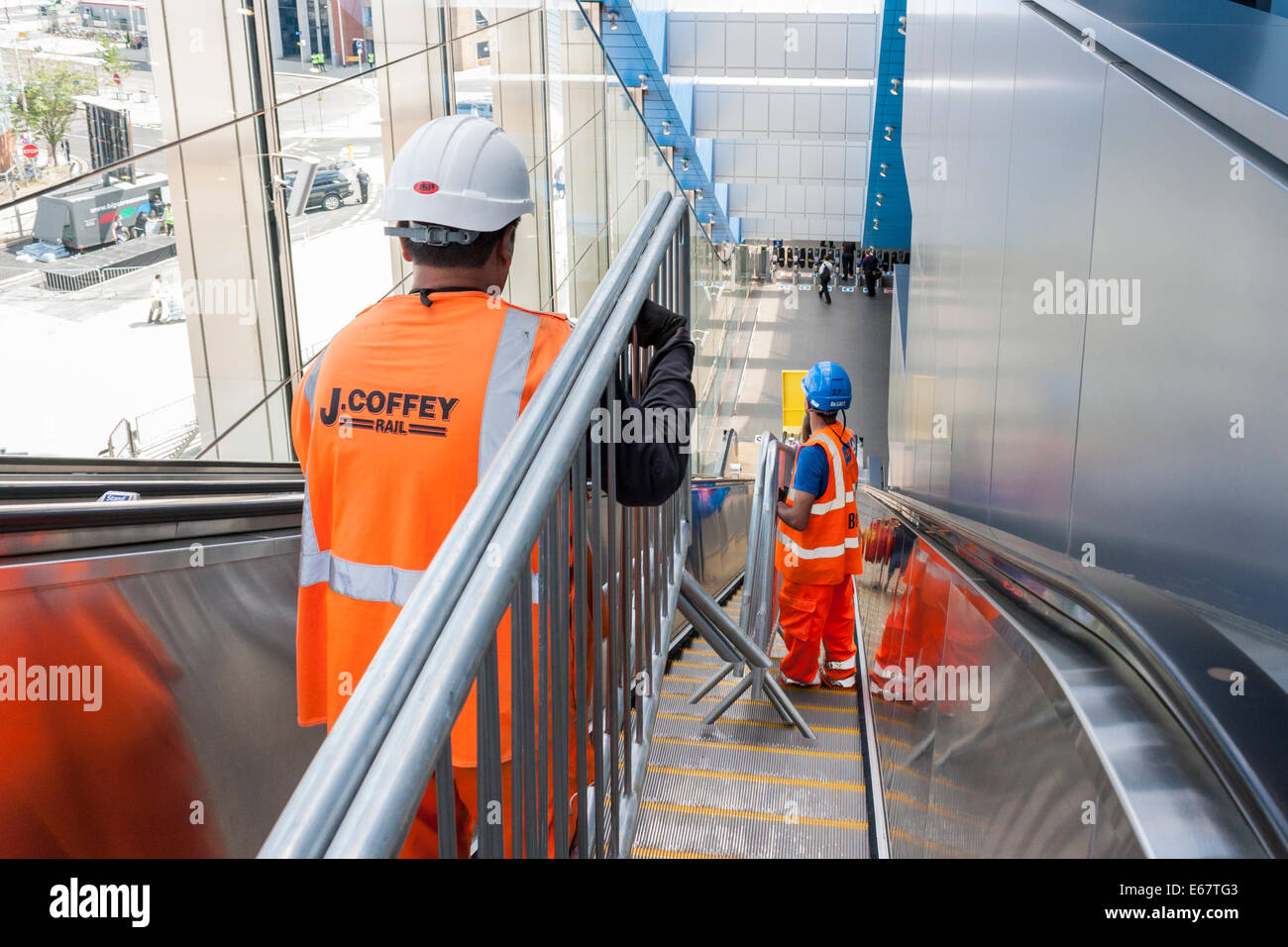 Workmen removing safety barriers down a public escalator after a public ...