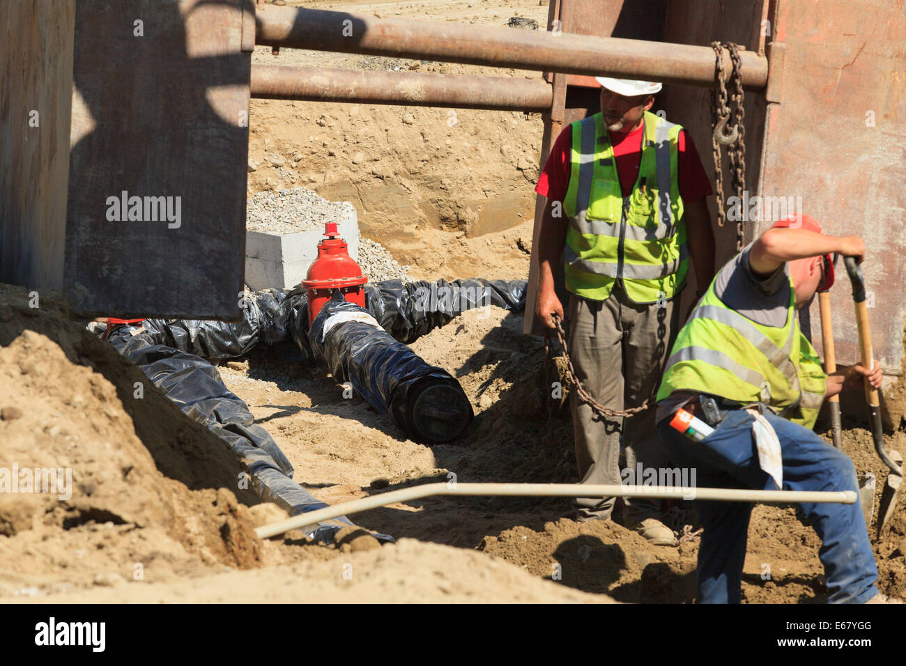 Construction engineers preparing trench for trench shield installation ...