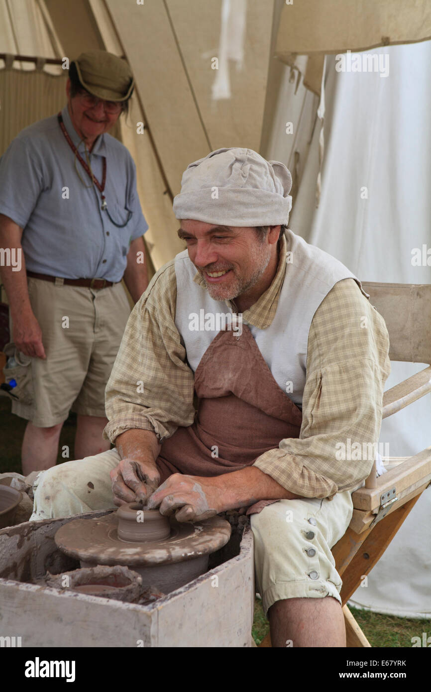 Man creating pottery with spectator in the background Stock Photo - Alamy