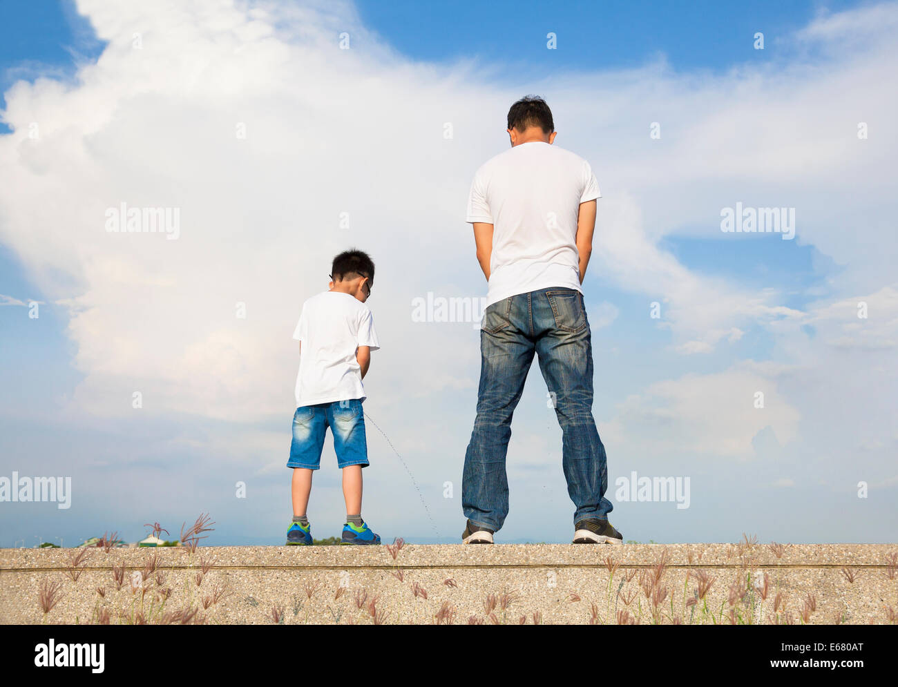 father and son standing on a stone platform and pee together Stock ...