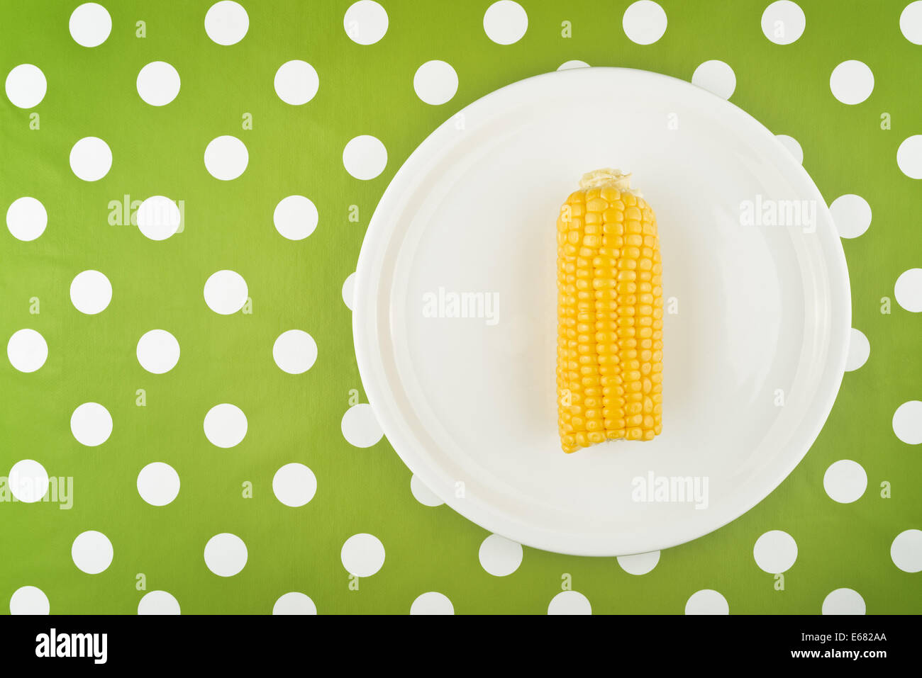 Cooked Corn maize cob half on a flat plate served as a dieting dinner ...