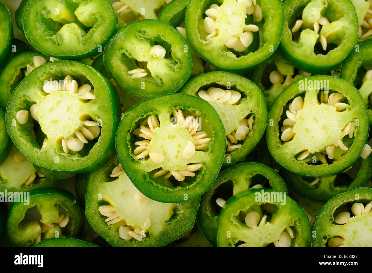sliced green jalapeno peppers background Stock Photo - Alamy