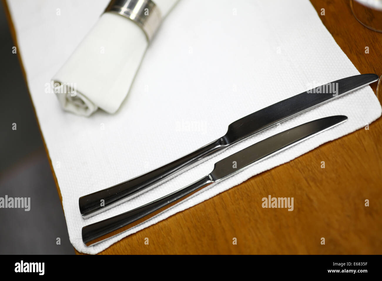 Two knives on a dinner table in a restaurant Stock Photo - Alamy