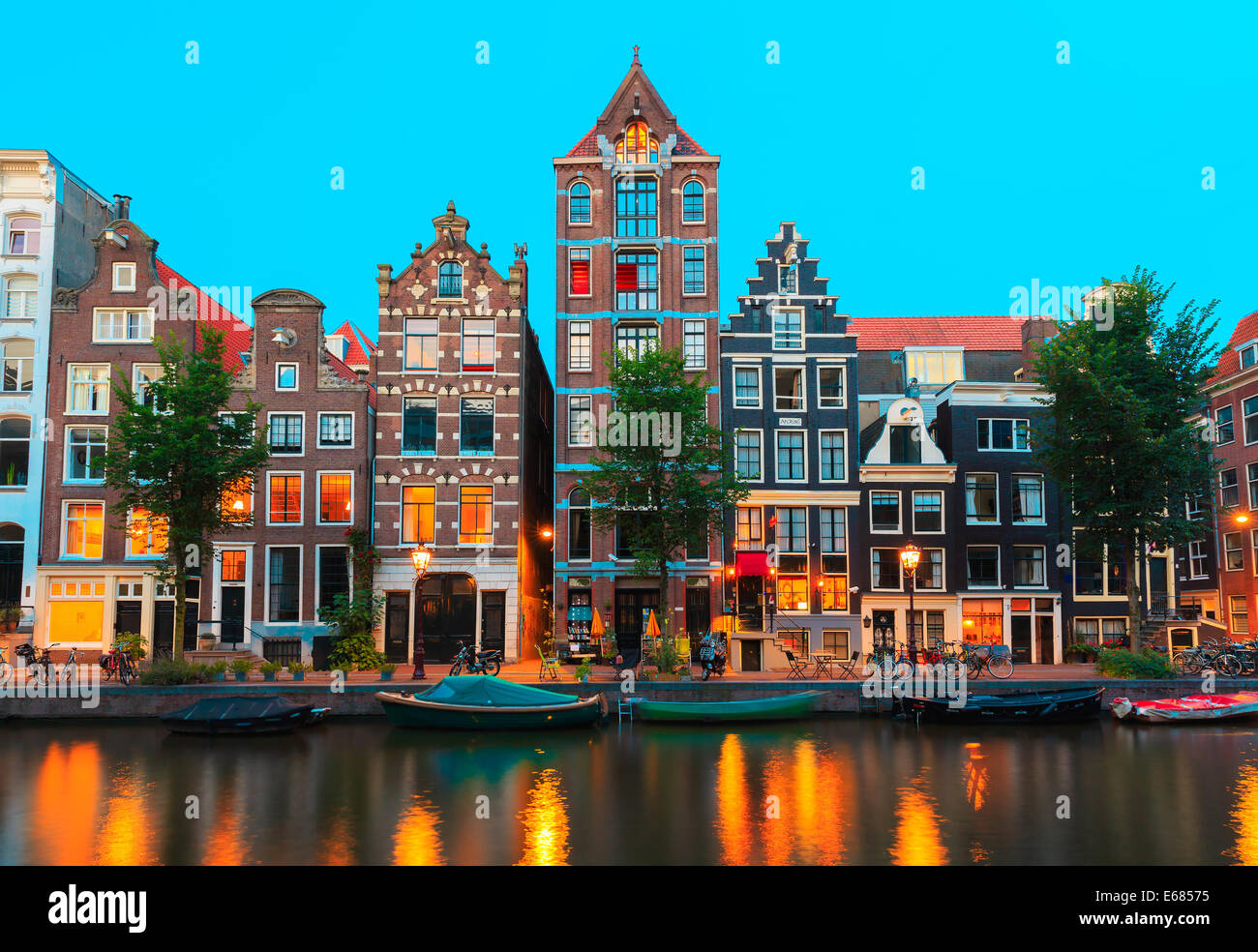 Night city view of Amsterdam canals and typical houses, boats and ...
