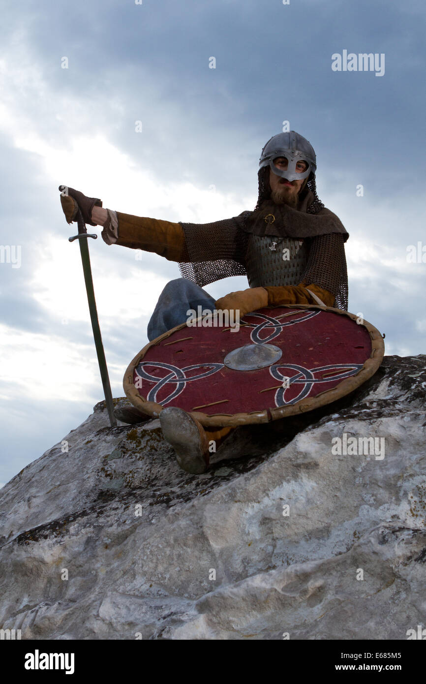 Knight sitting on a rock with a sword against blue cloudy sky Stock ...