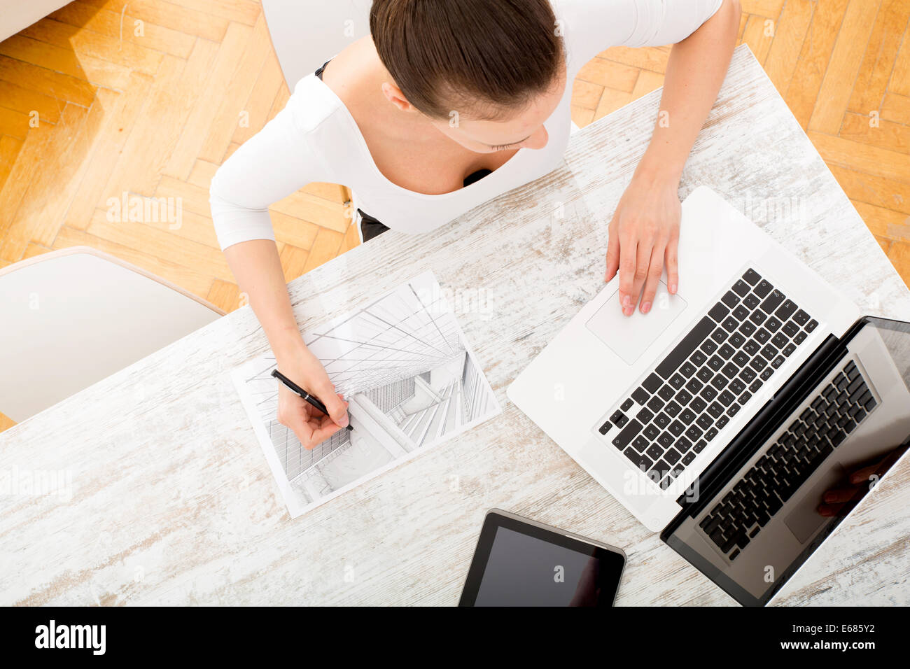A young adult woman developing a architectural plan at home Stock Photo ...