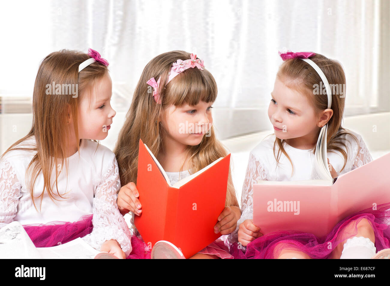 Girls reading book Stock Photo - Alamy