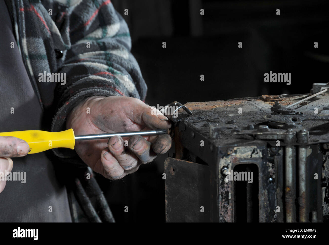 Man using screwdriver on metal car part Stock Photo - Alamy