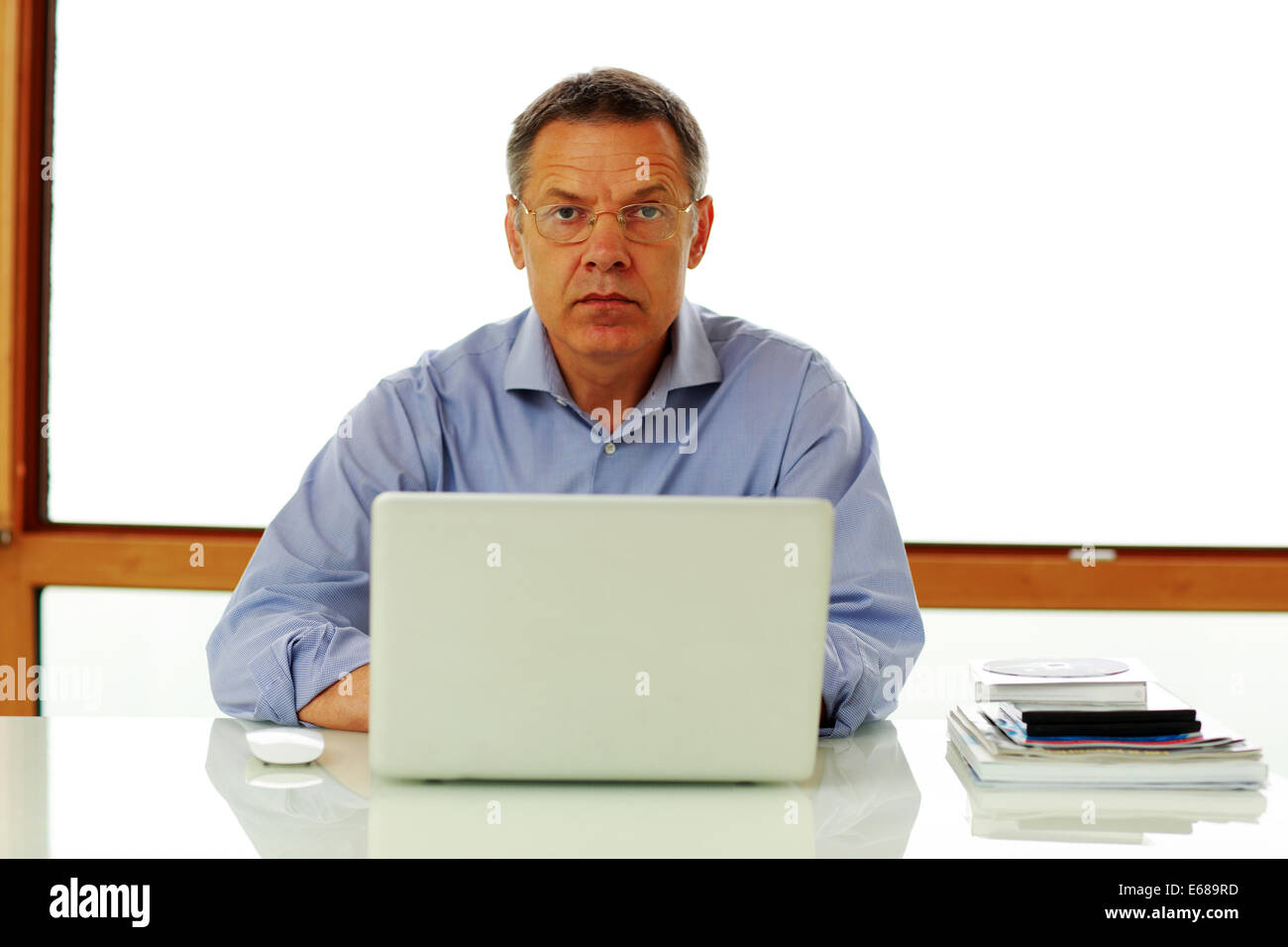 Portrait of a middle aged man sitting on the table with laptop computer ...