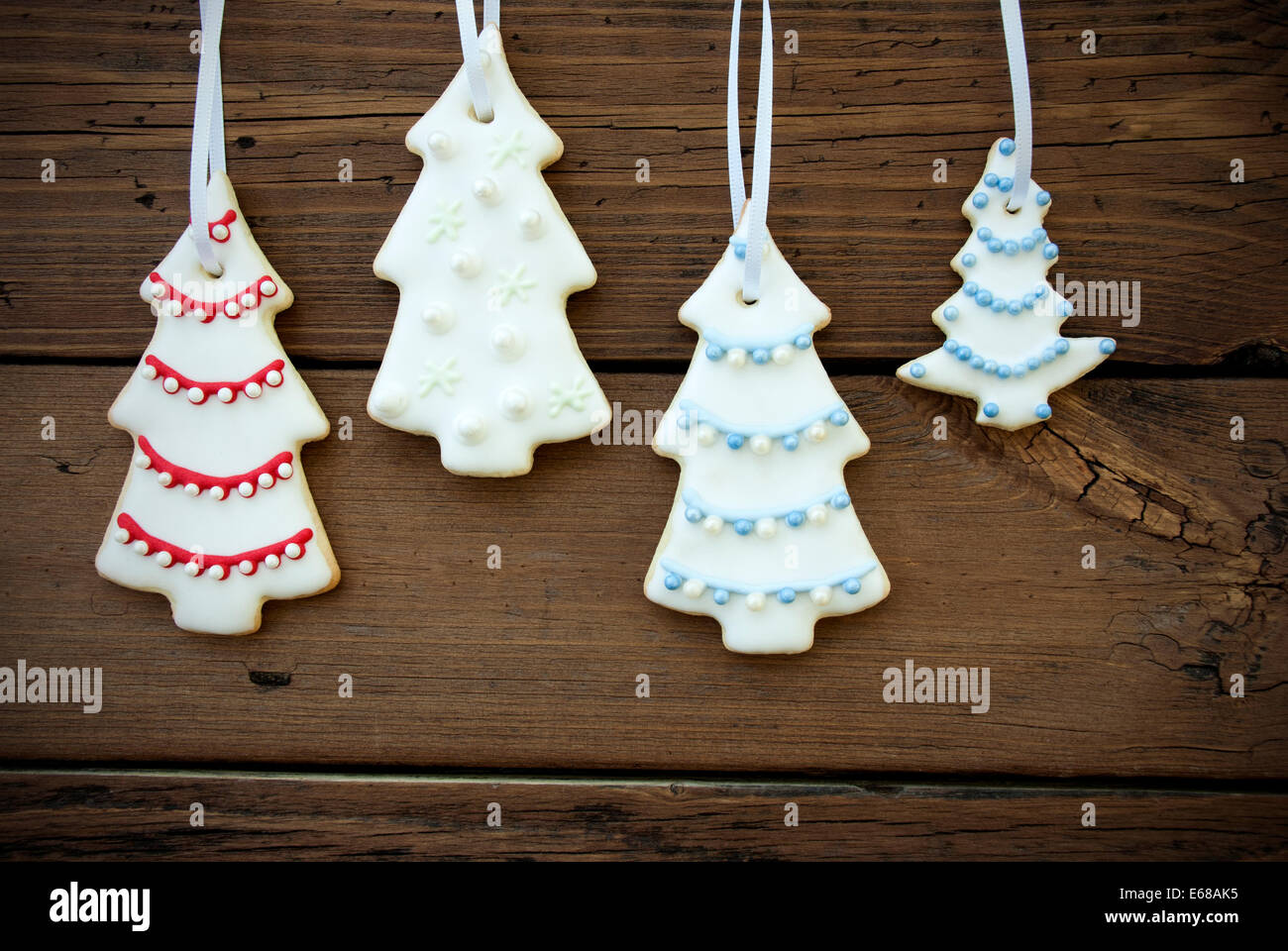 Four Christmas Tree Cookies with different Decorations Hanging on a ...