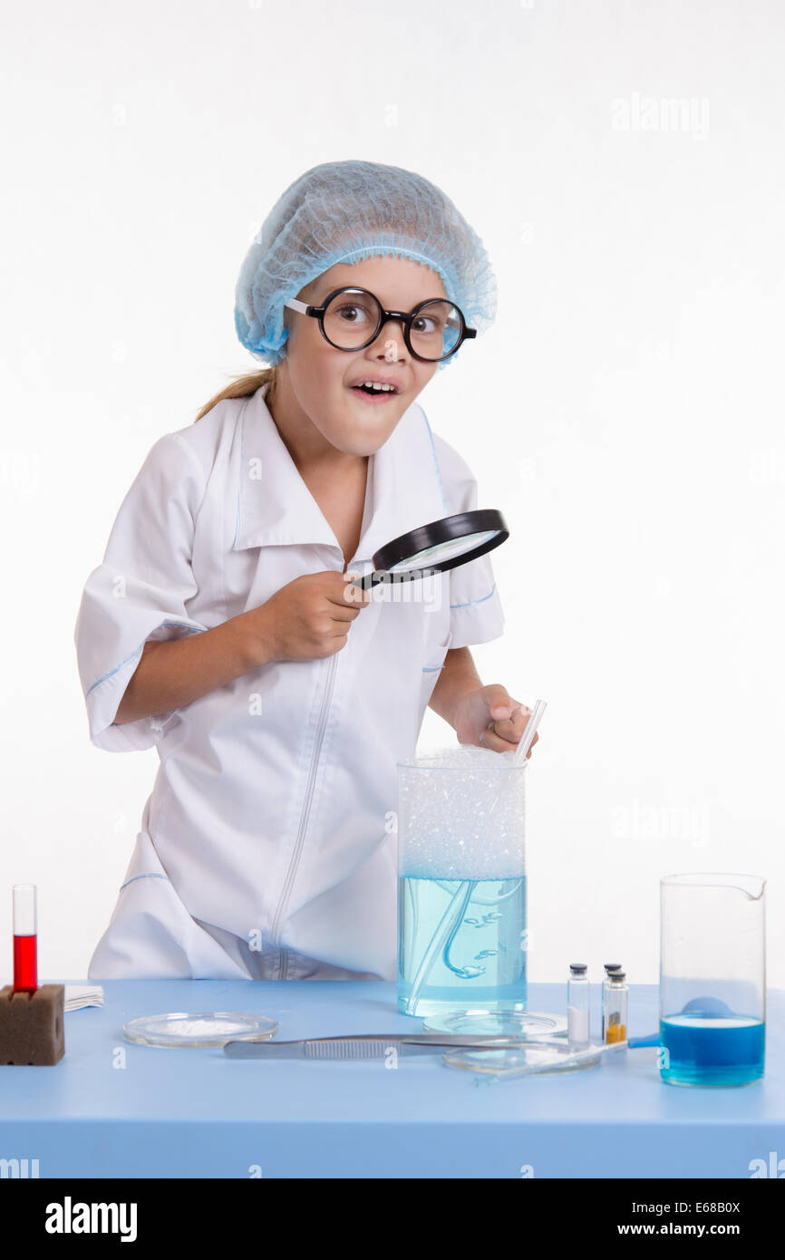Chemist girl sitting at the table with the reagents in chemistry class ...