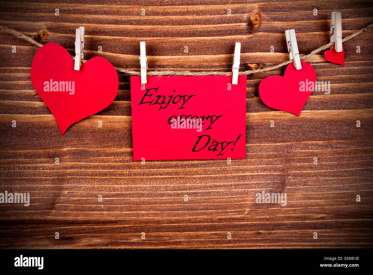 The Saying Enjoy every Day on a red Label with Hearts Hanging on a Line ...