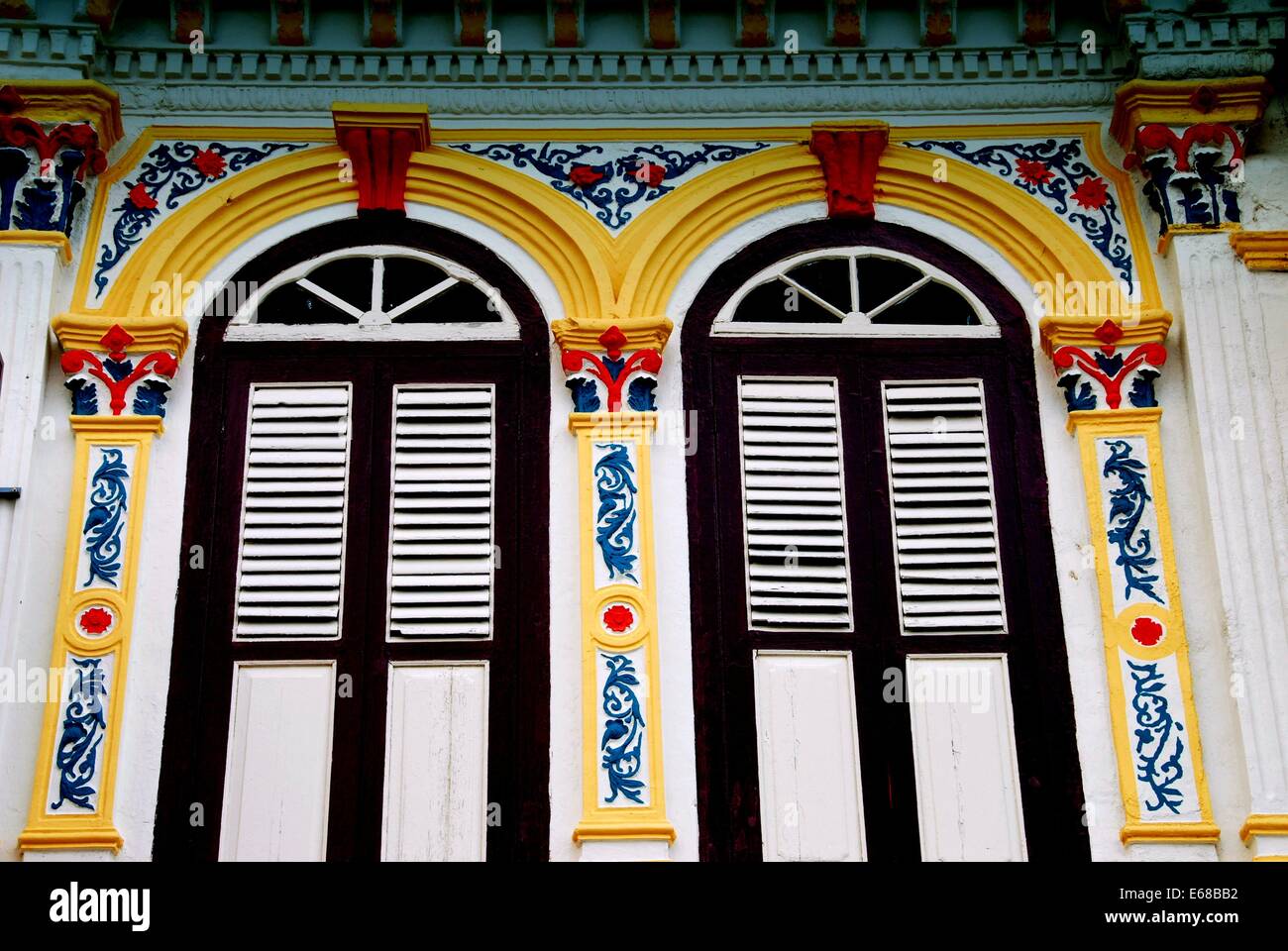 MELAKA, MALAYSIA: Pargetted plasterwork designs frame louvered shutter ...