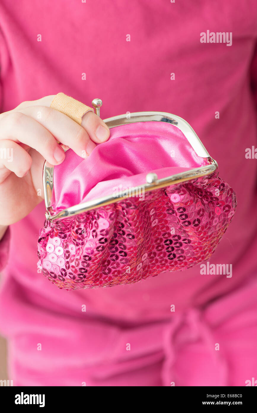 Hand of little girl holding pink change purse Stock Photo - Alamy