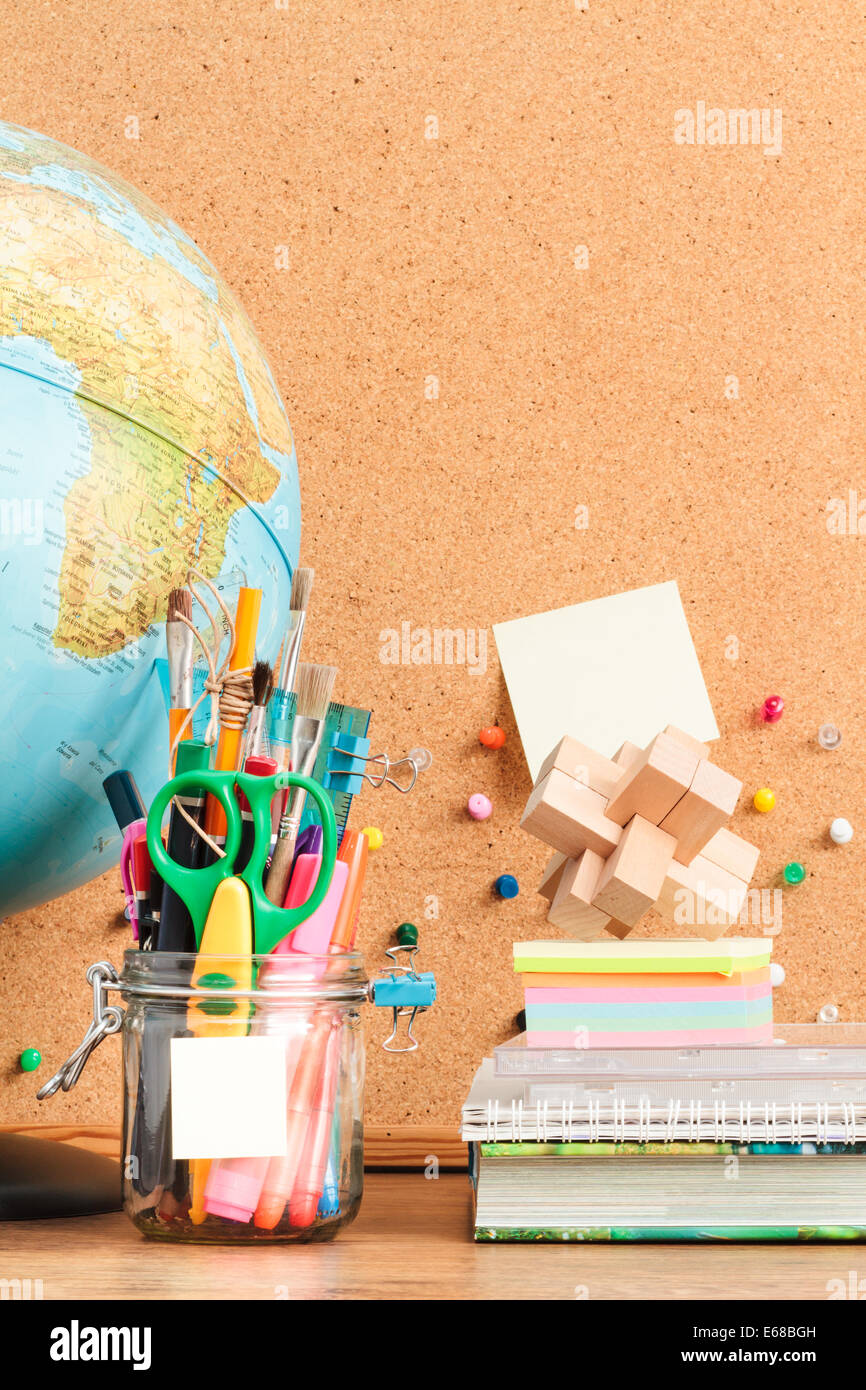 School accessories on desktop with blank pinboard in the background ...