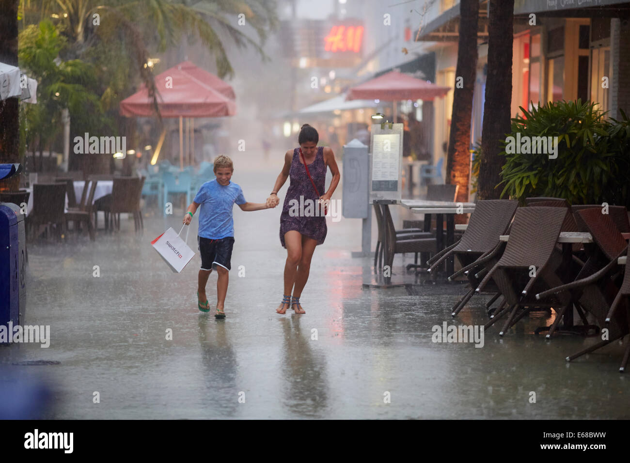 A picture of mother and son run throughout he street in the heavy rain ...