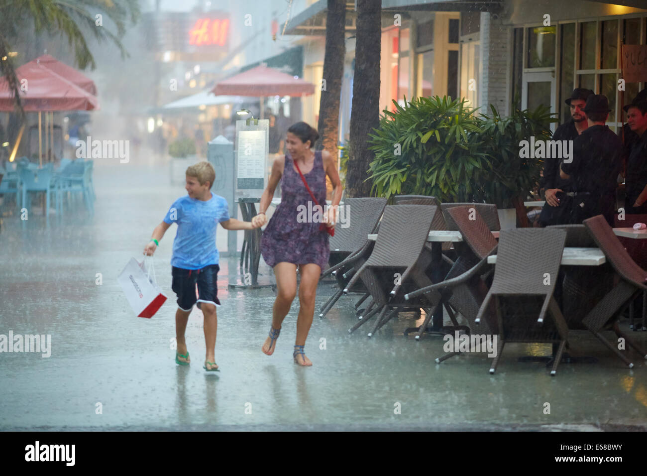 A picture of mother and son run throughout he street in the heavy rain ...