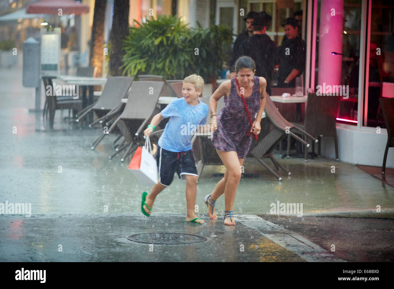 A picture of mother and son run throughout he street in the heavy rain ...