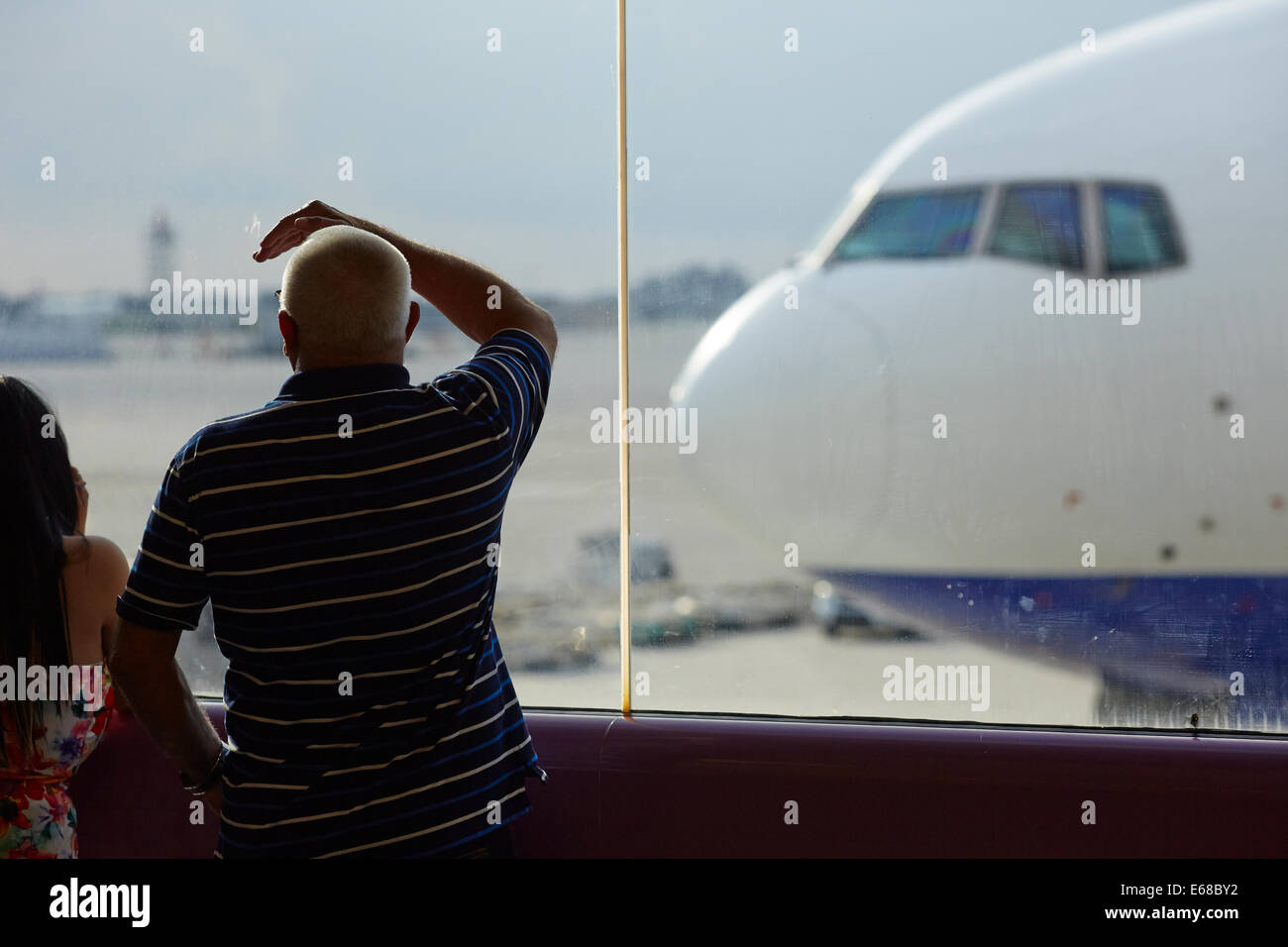 Woman looking through window of plane hi-res stock photography and ...