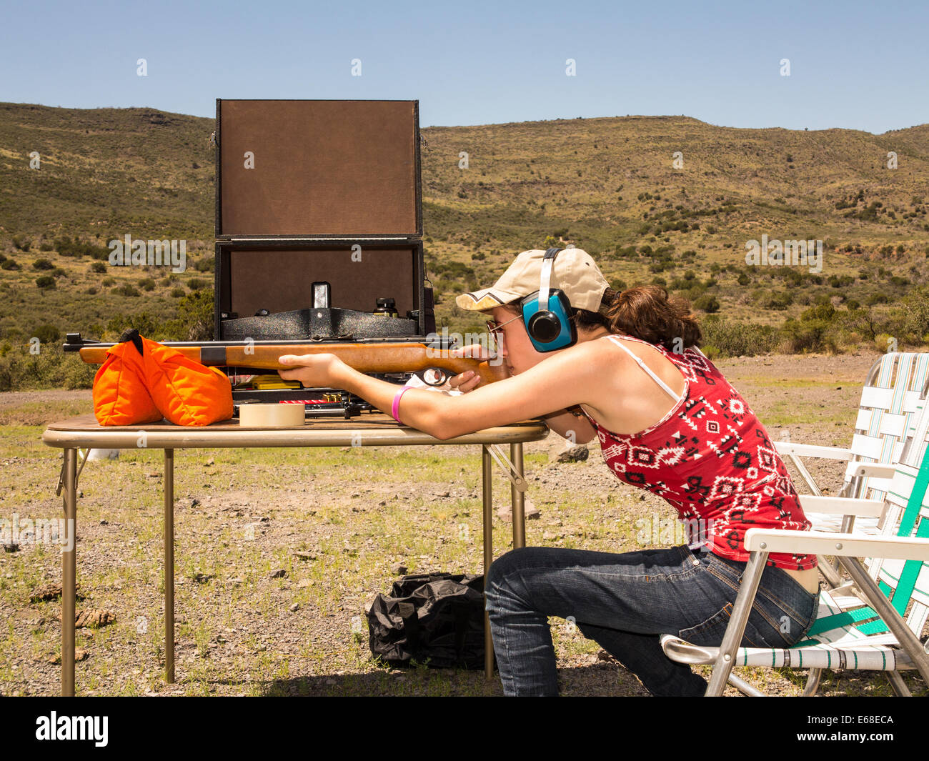 A teenage girl shooting a small caliber rifle from a bench in the ...