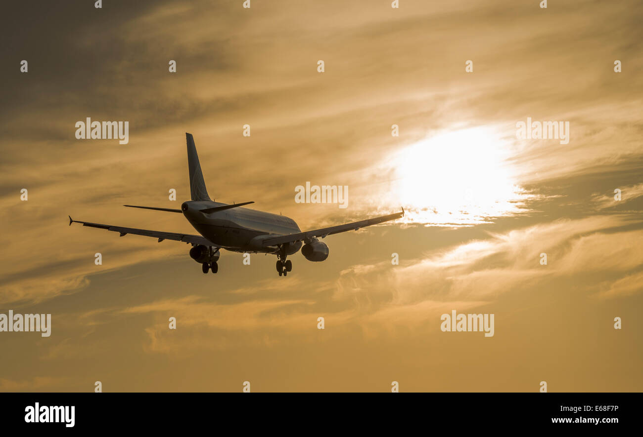 An airplane flying into the sunset Stock Photo - Alamy