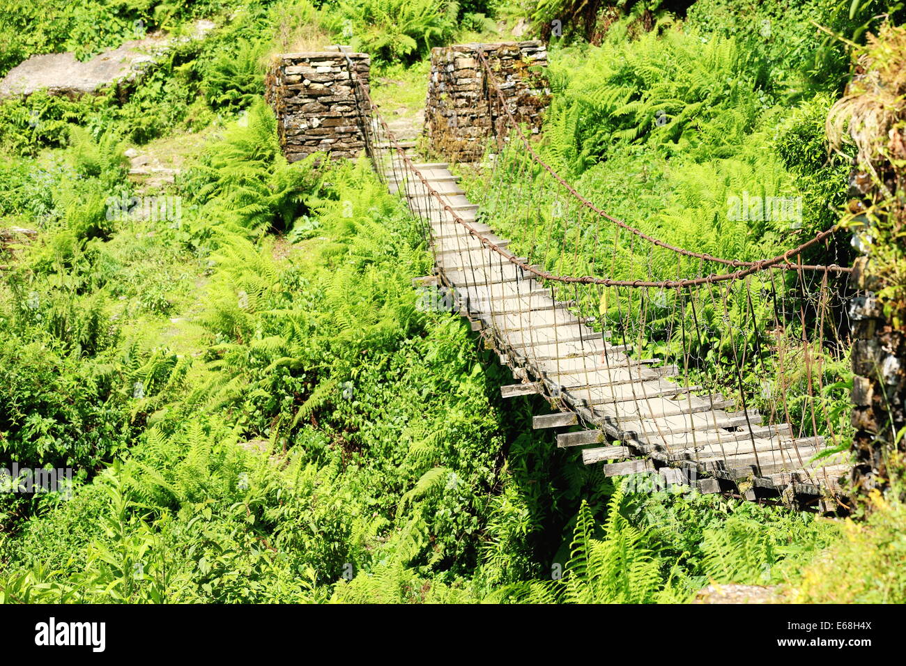 Steel cable and wooden floor suspension bridge crossing a mountain ...