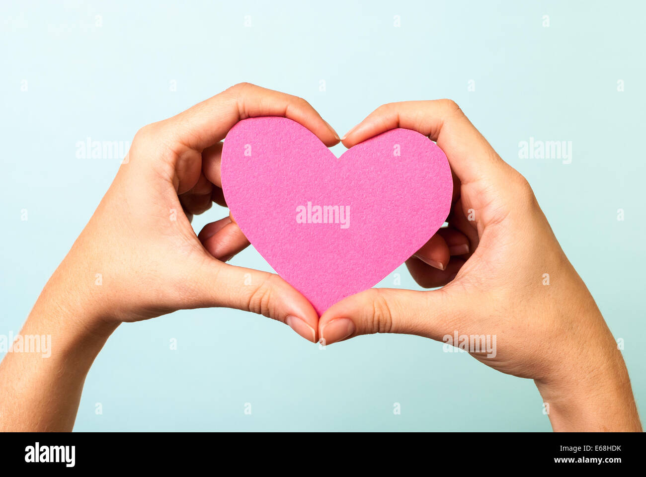 Pink love shape on blue background Stock Photo - Alamy